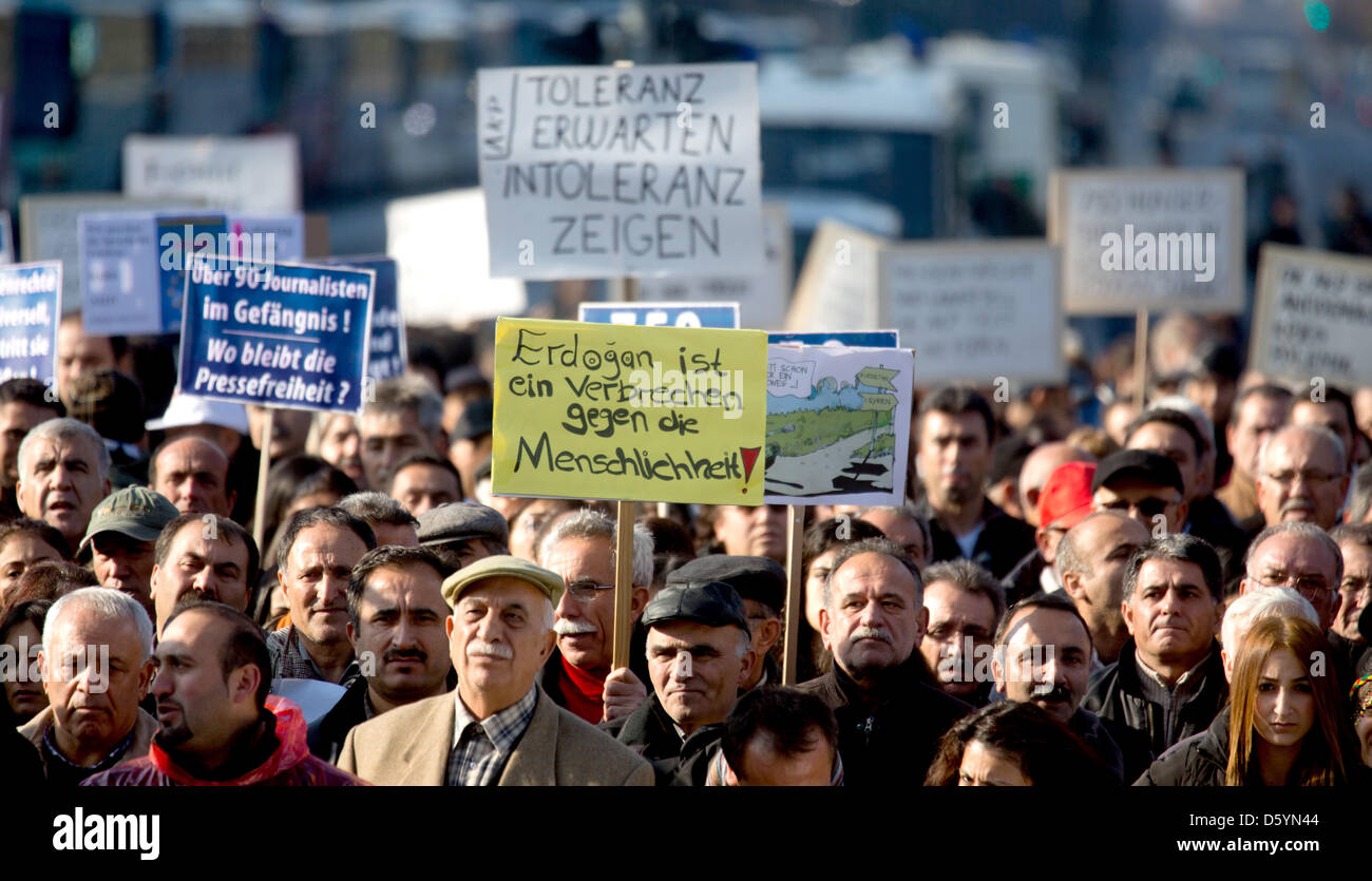 Demonstrators hold placards as they demonstrate against the policy of ...