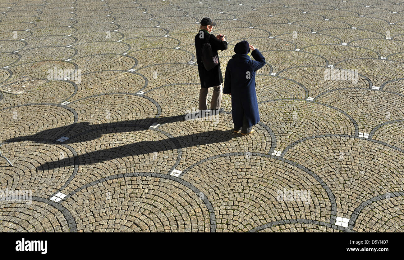 Passers-by throw long shadows in brilliant sunshine at Koenigsplatz in ...