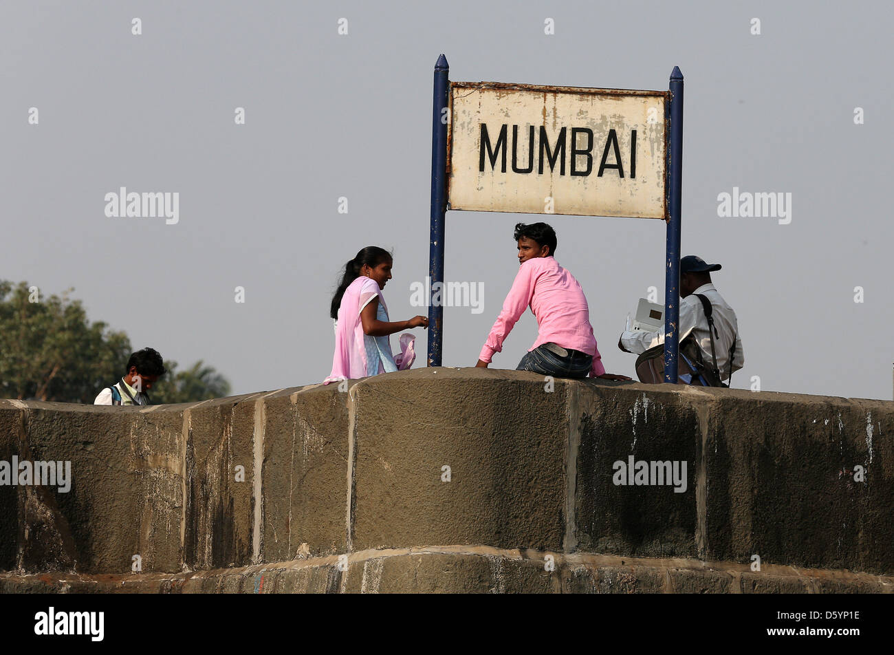 Young Indian sit on a wall at the India Gate in Mumbai, India, 18 ...