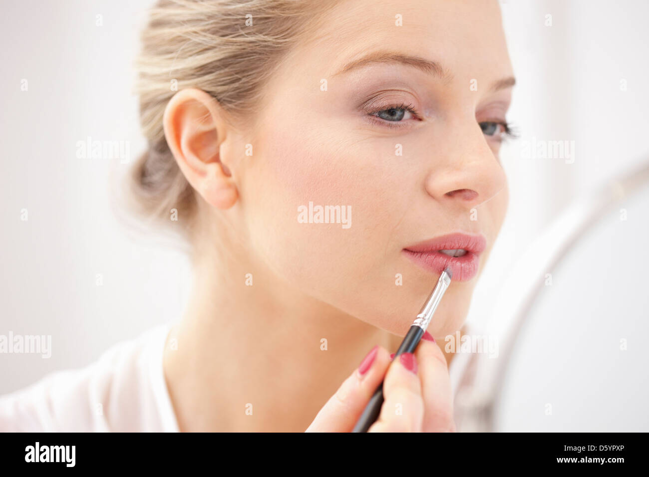 Young Woman Applying Lipstick High Resolution Stock Photography and ...