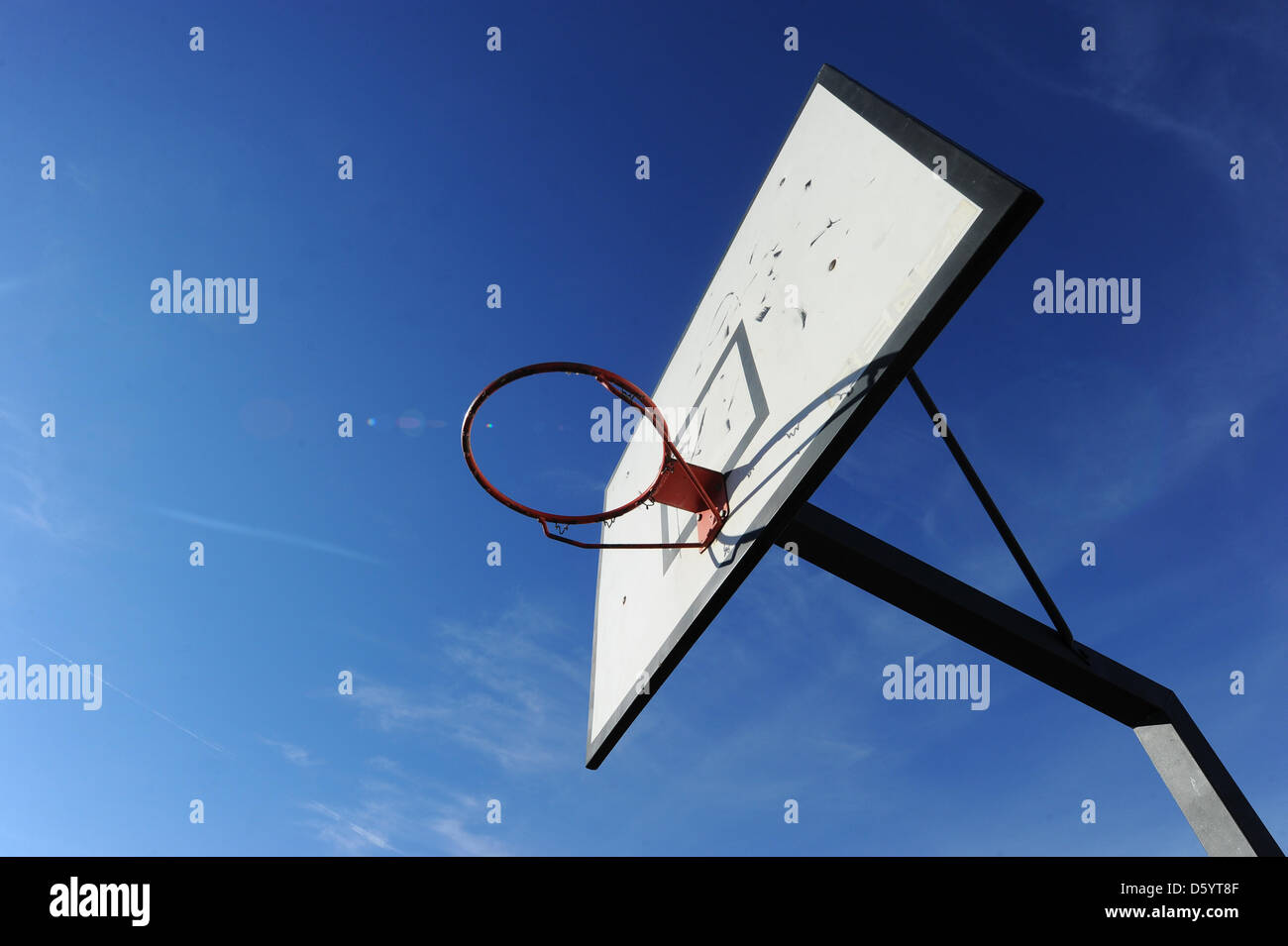 A basketball basket with a missing net stands on a sports field in ...