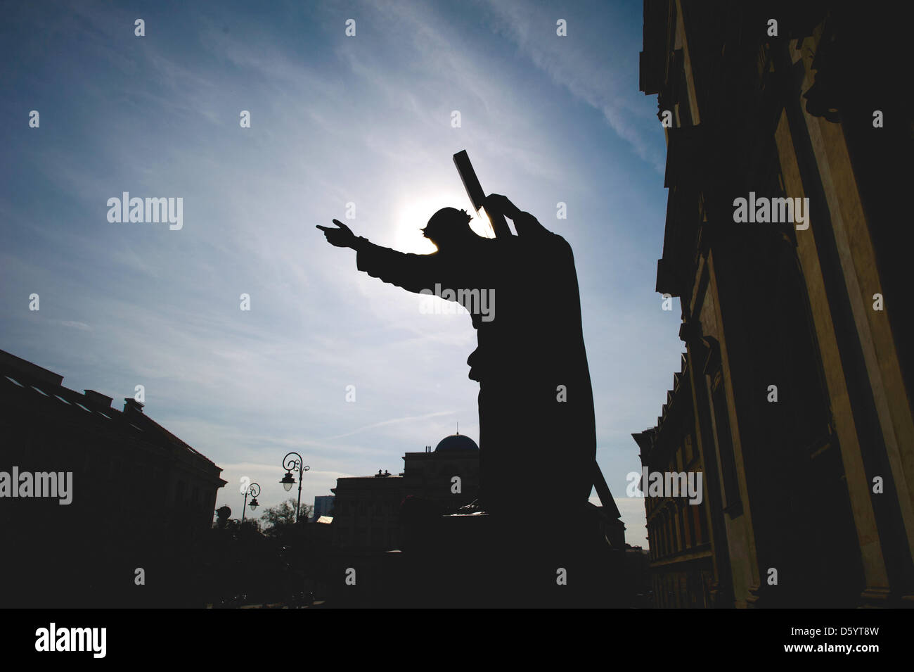 A jesus statue is pictured in the backlight before a church in Warsaw ...