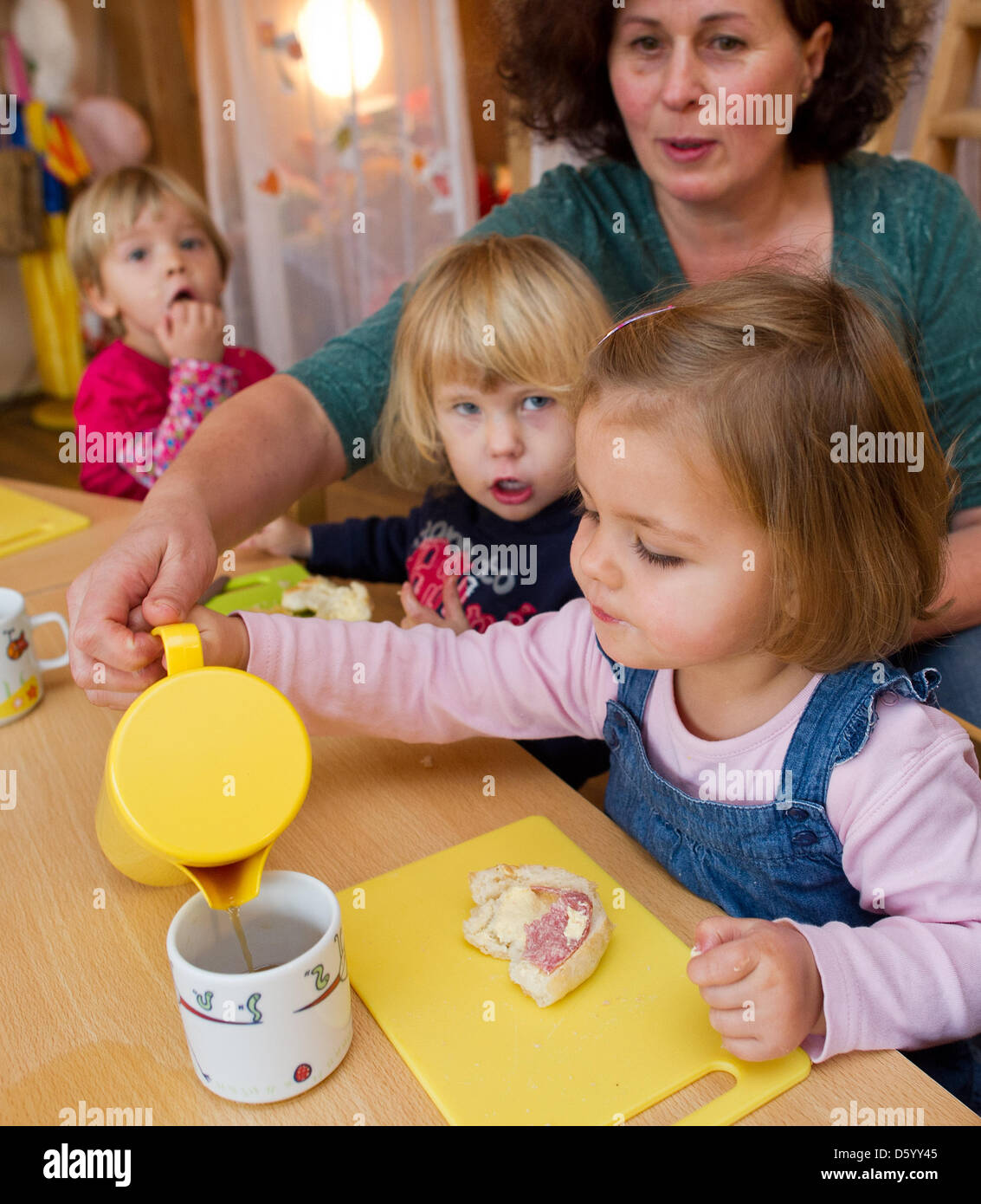 Daycare teacher Renate and pre-school children eat breakfast at ...