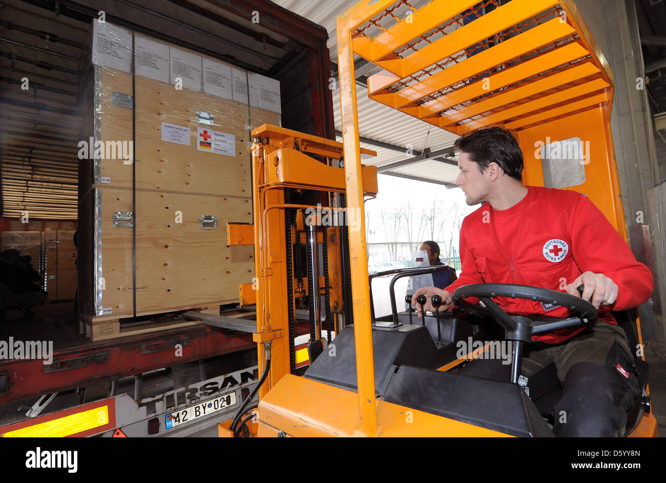 A German Red Cross employee loads first humanitarian aid parcels for ...