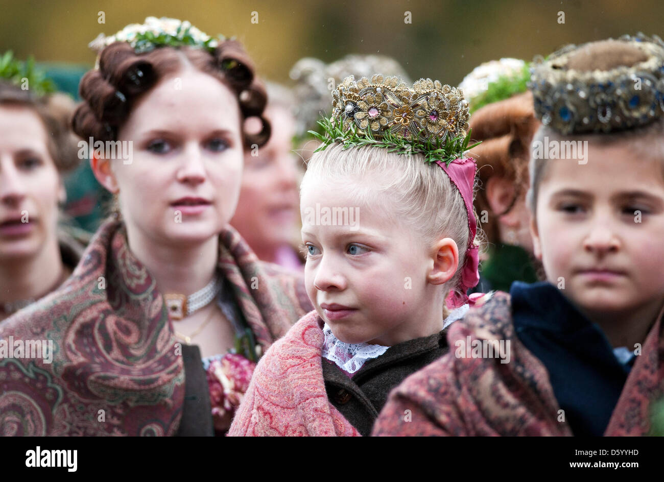 Girls and women in traditional costume sit on a decorated cart during ...