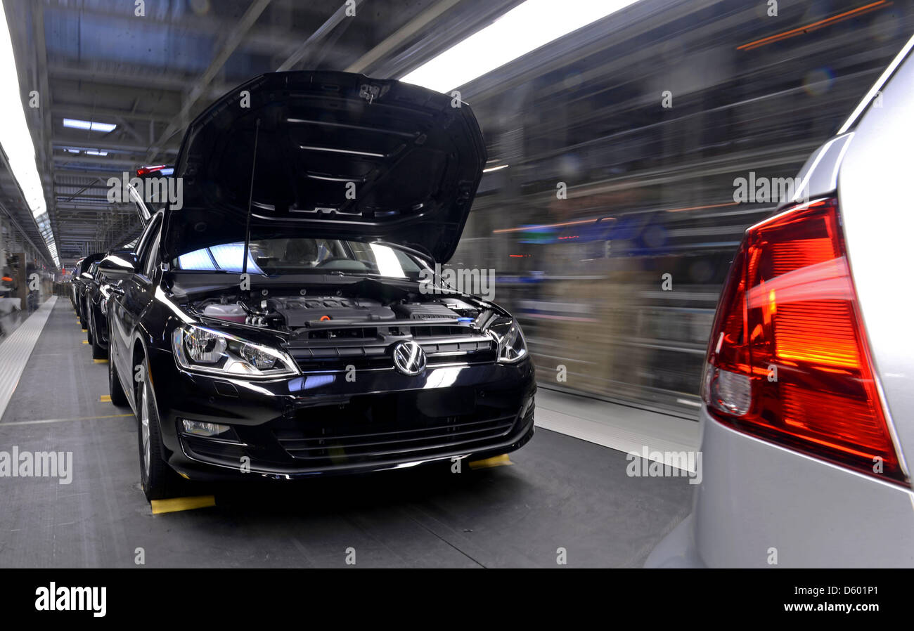 A new Golf 7 is transported on a conveyor belt through Volkswagen ...