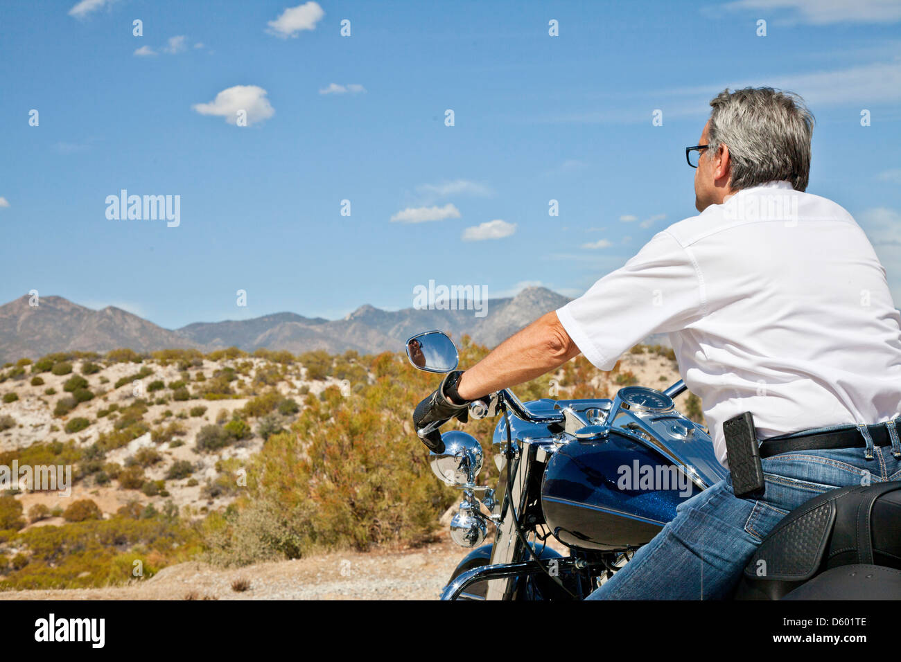 Senior man riding motorcycle through the desert Stock Photo - Alamy