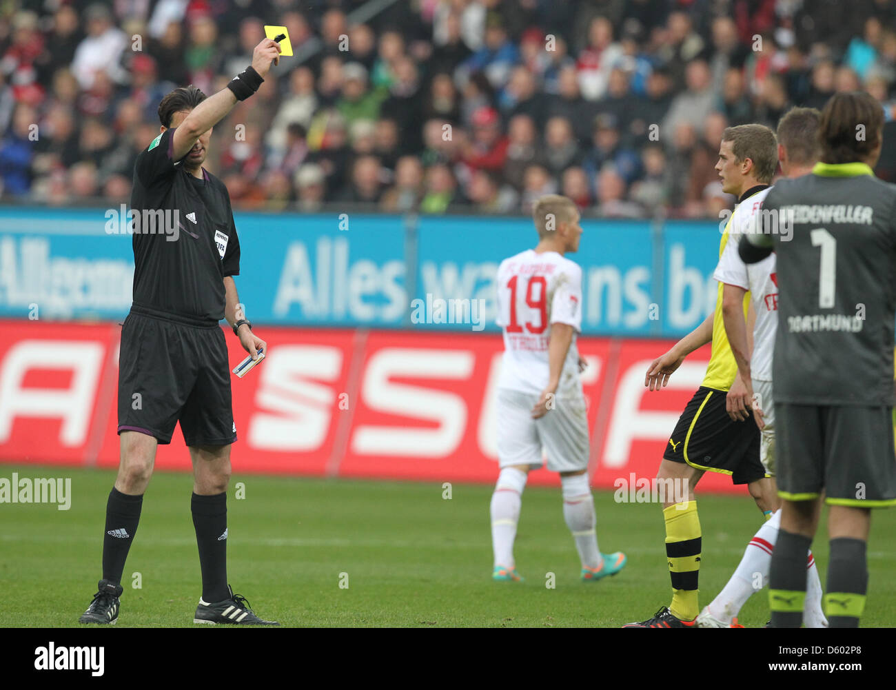 Referee Manuel Graefe gives Dortmund's Sven Bender (R) the yellow card ...