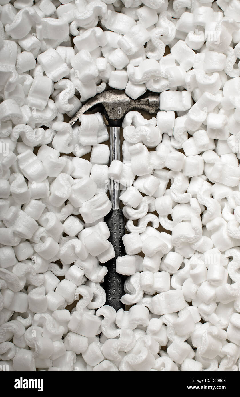 Hammer protected from packing peanuts. Allegory on packaging protection ...
