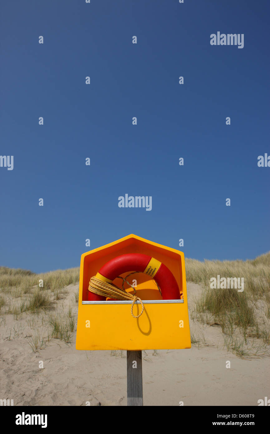 Life saving device at the beach red lifeguard ring buoy in yellow ...