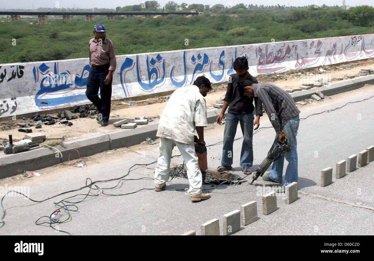 KARACHI, PAKISTAN, APR 10: Laborers busy in repairing work of a flyover ...