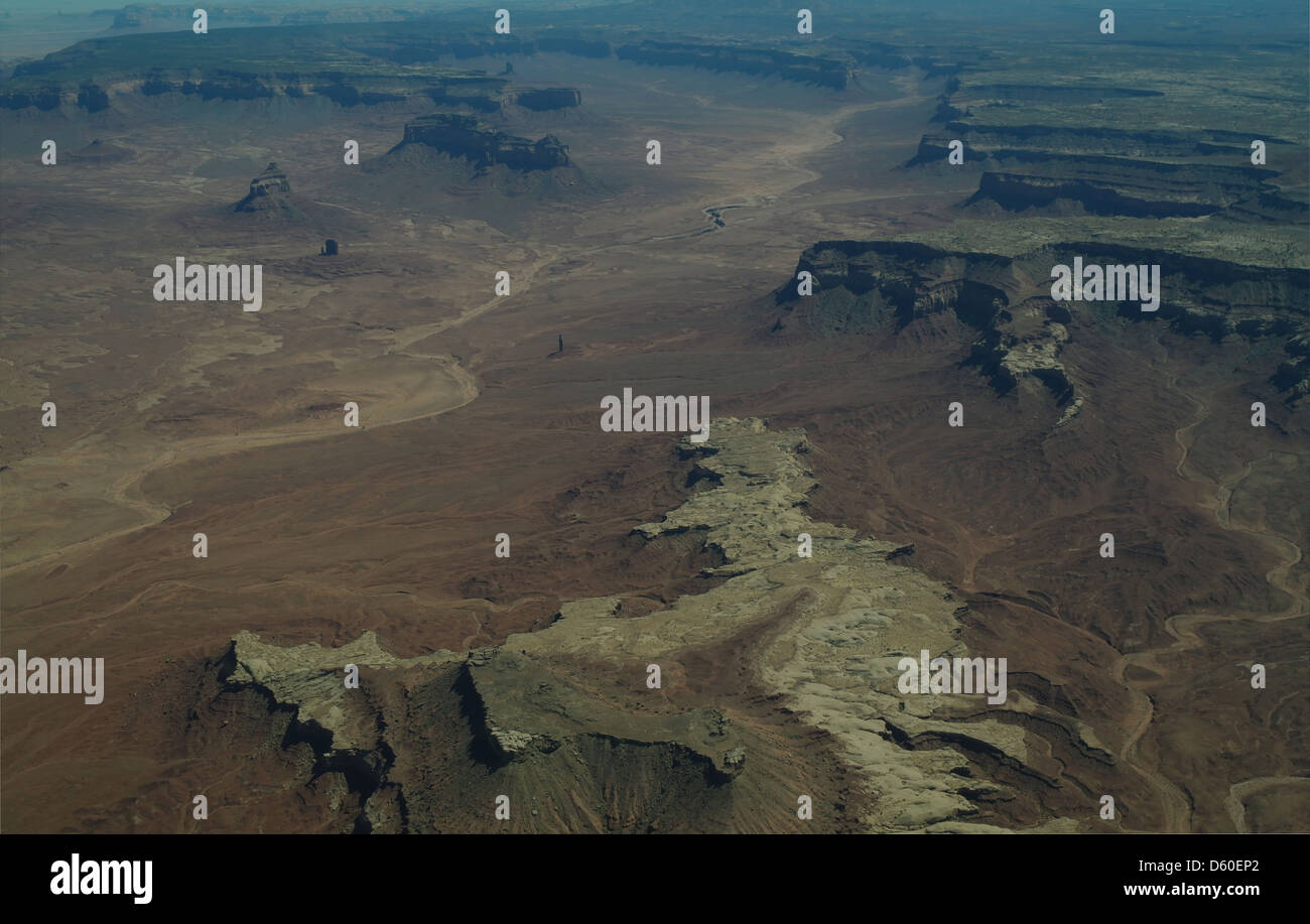 Aerial view rocks strata mesa rising dry stream channel floor Piute ...