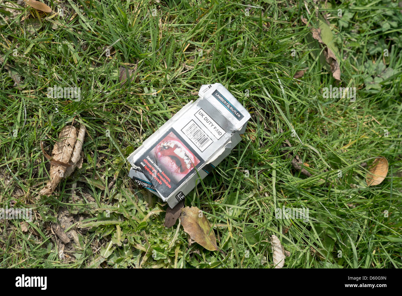 Discarded empty cigarette packet with health warning and bar code on ...