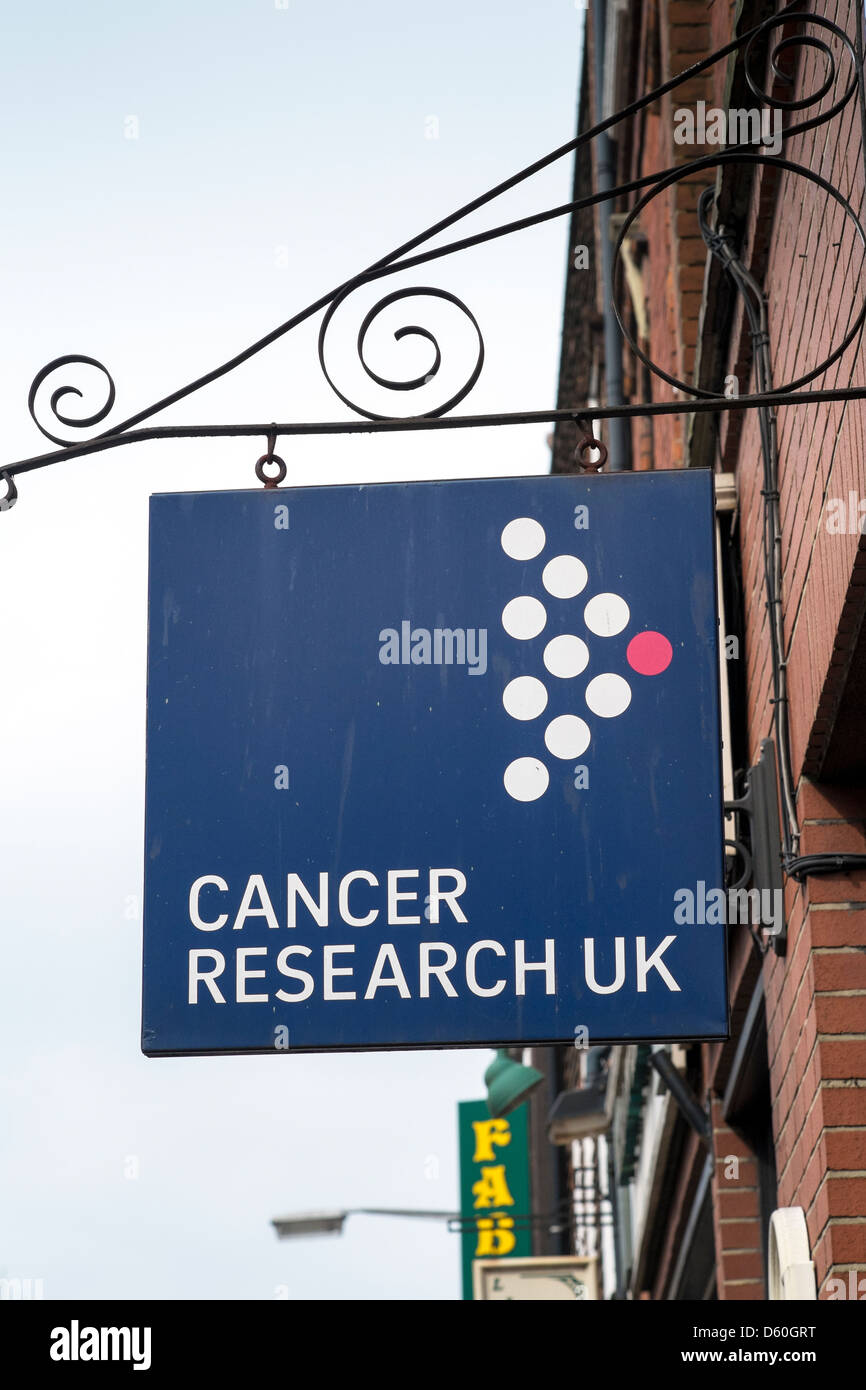 Looking up at Cancer Research UK charity shop sign on UK high street ...