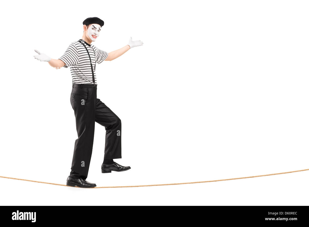 Full length portrait of a male mime artist walking on a rope, isolated ...