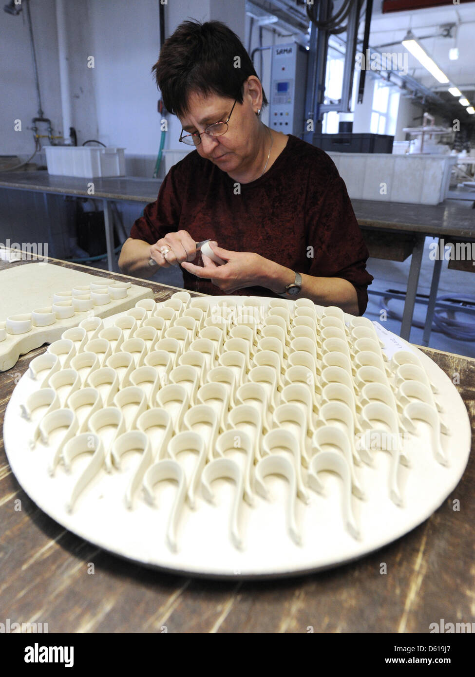 A staff member produces handles for coffee cups at the Fuerstenberg ...