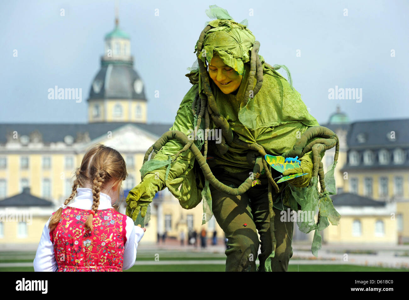 A female pantomime artist in a green costume poses in front of ...