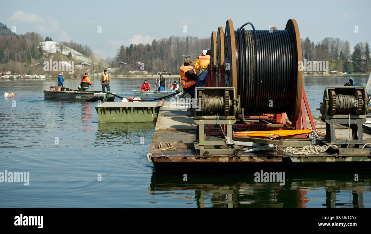 Employees of energy giant Eon lay a 20,000 volt undersea cable from a ...