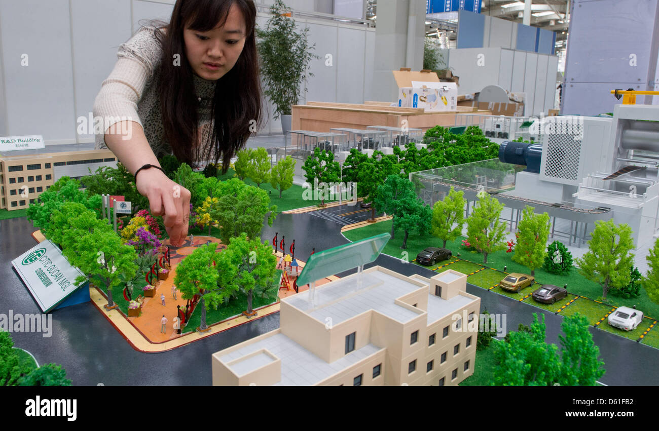 An employee of the China stand puts figures onto a model of a battery ...