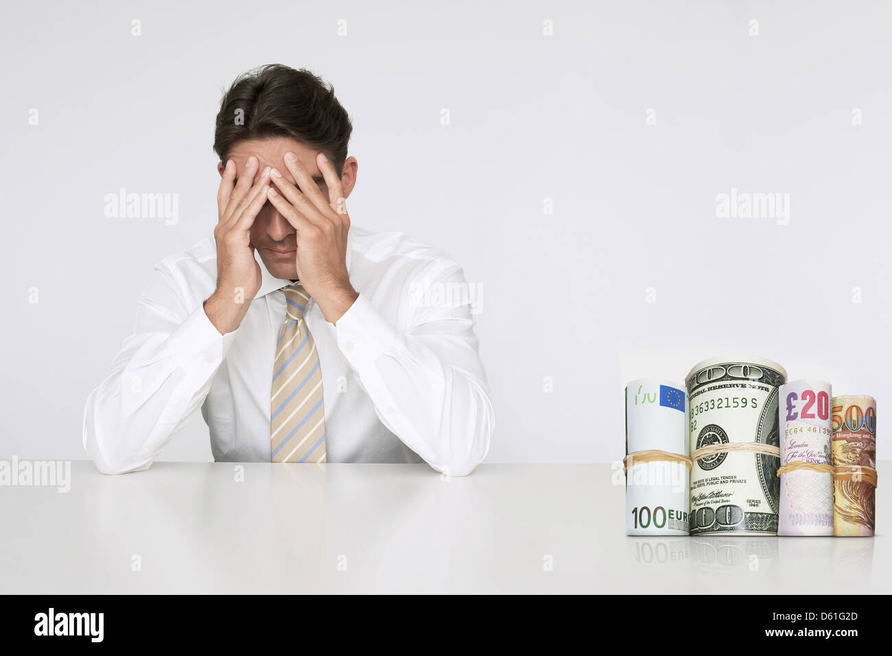 Money rolls with worried businessman on chair representing financial ...