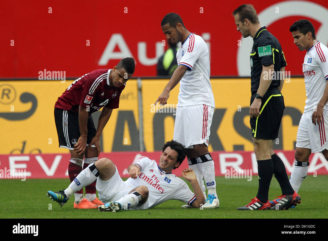 Hamburg's Gojko Kacar lies on the pitch injured next to team-mate ...