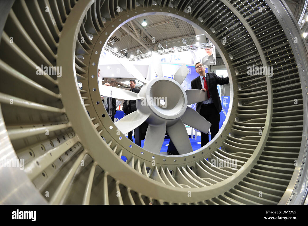 A visitor looks at the rotor of a wind turbine at the industrial fair ...