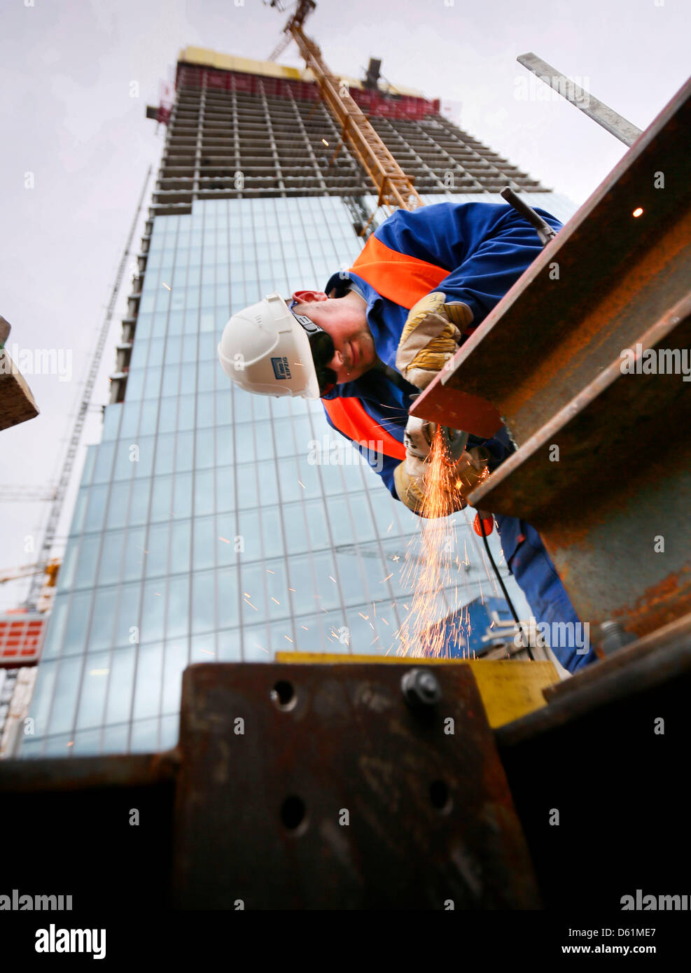 A workman grinds a steel beam at the construction site of the new ...