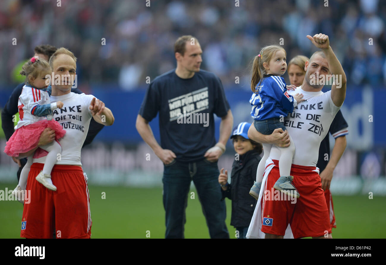 Hamburg's Mladen Petric (R) and David Jarolim (L) carry their daughter ...