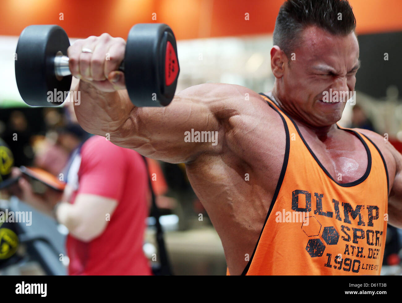 Cologne, Germany. 11th April 2013. A bodybuilder trains with a dumbbell ...