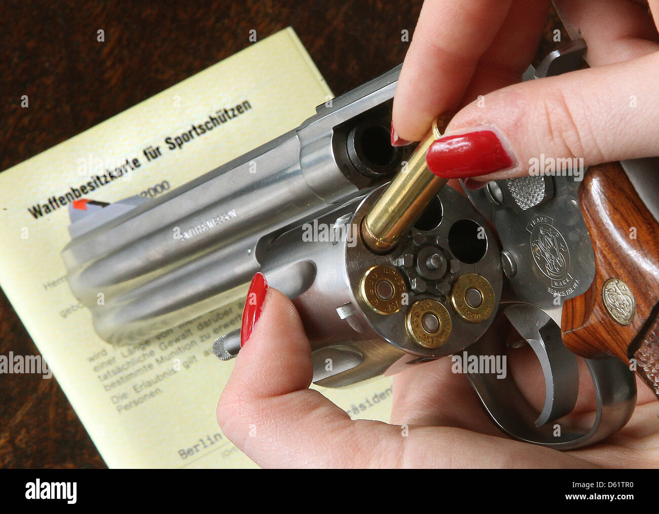 A female marksman loads her gun at a shooting range in Berlin, Germany ...