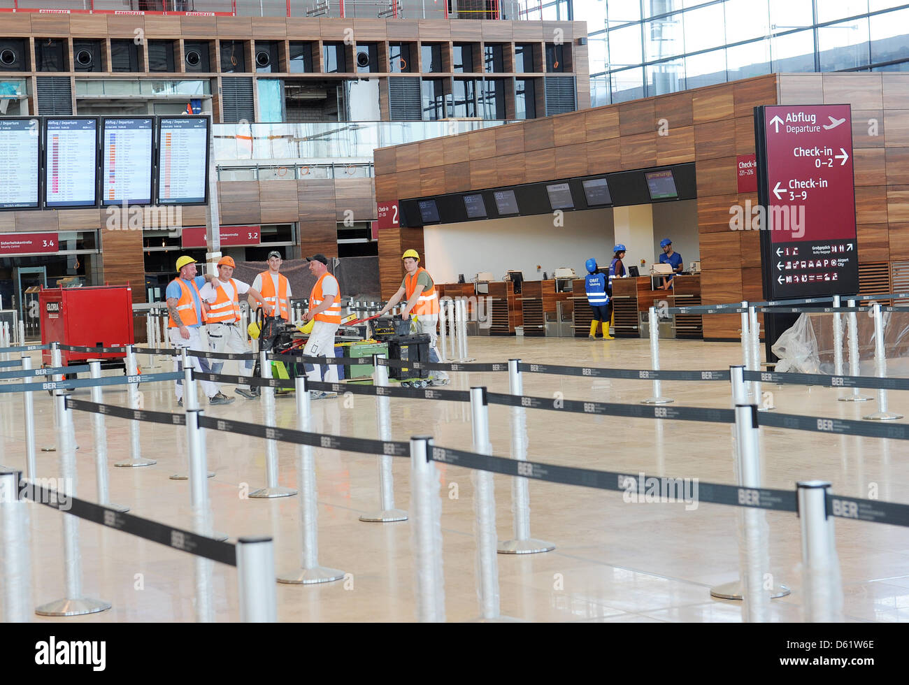 Construction workers stand in the check-in area in the main hall of the ...