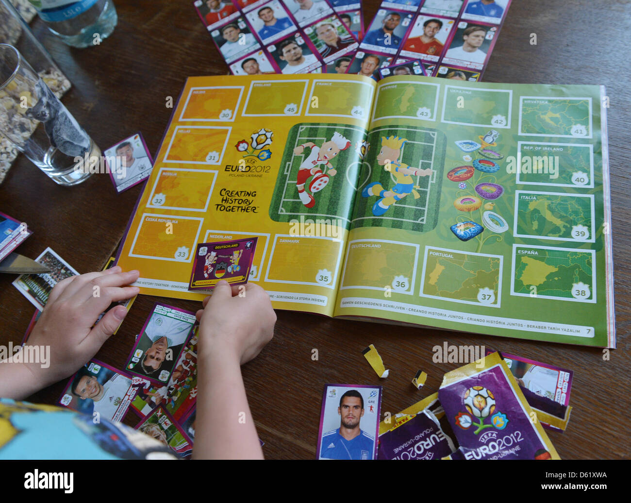 A boy opens a Panini-sticker package and puts them into his official ...