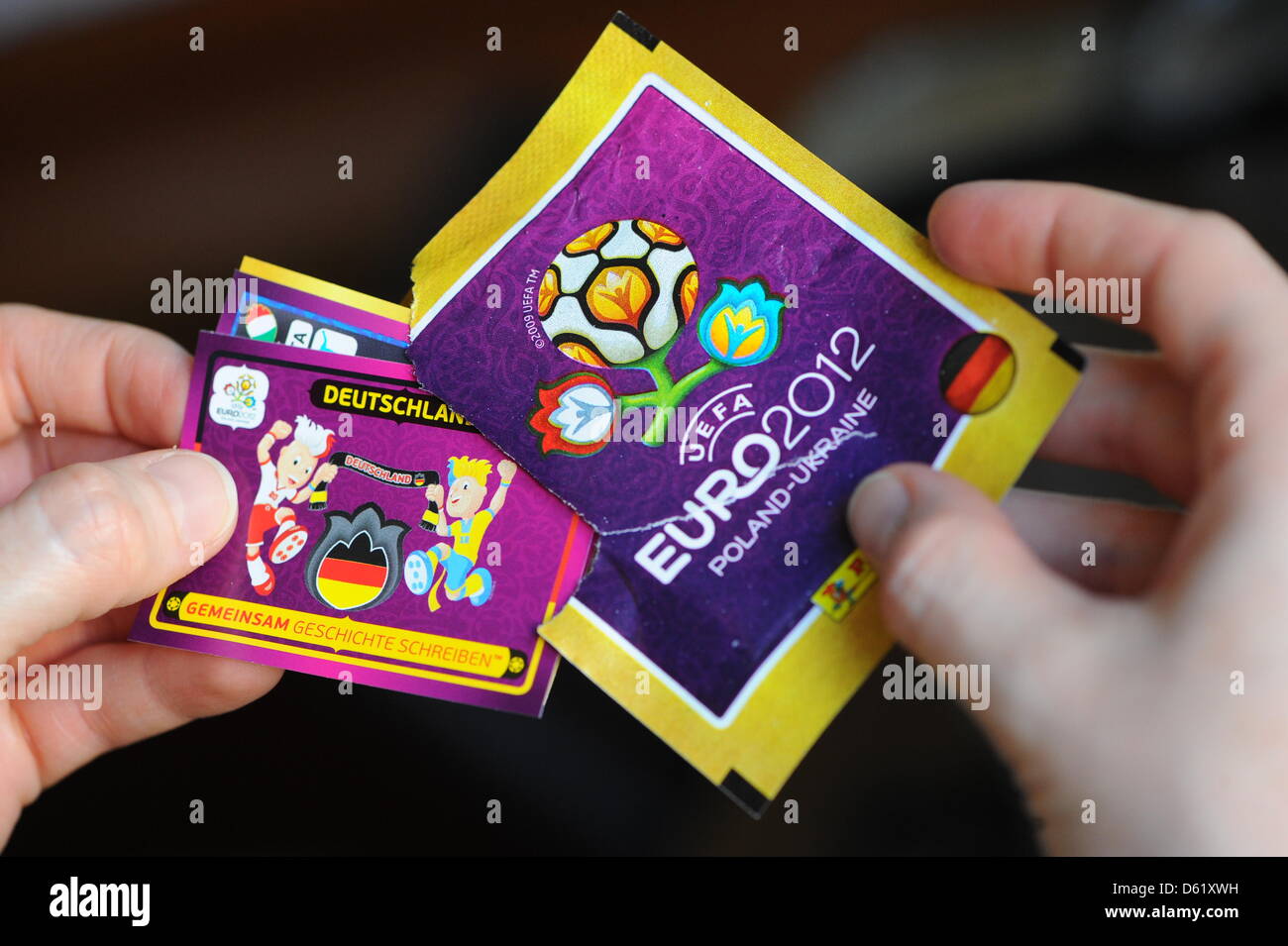 A boy opens a Panini-sticker package and puts them into his official ...