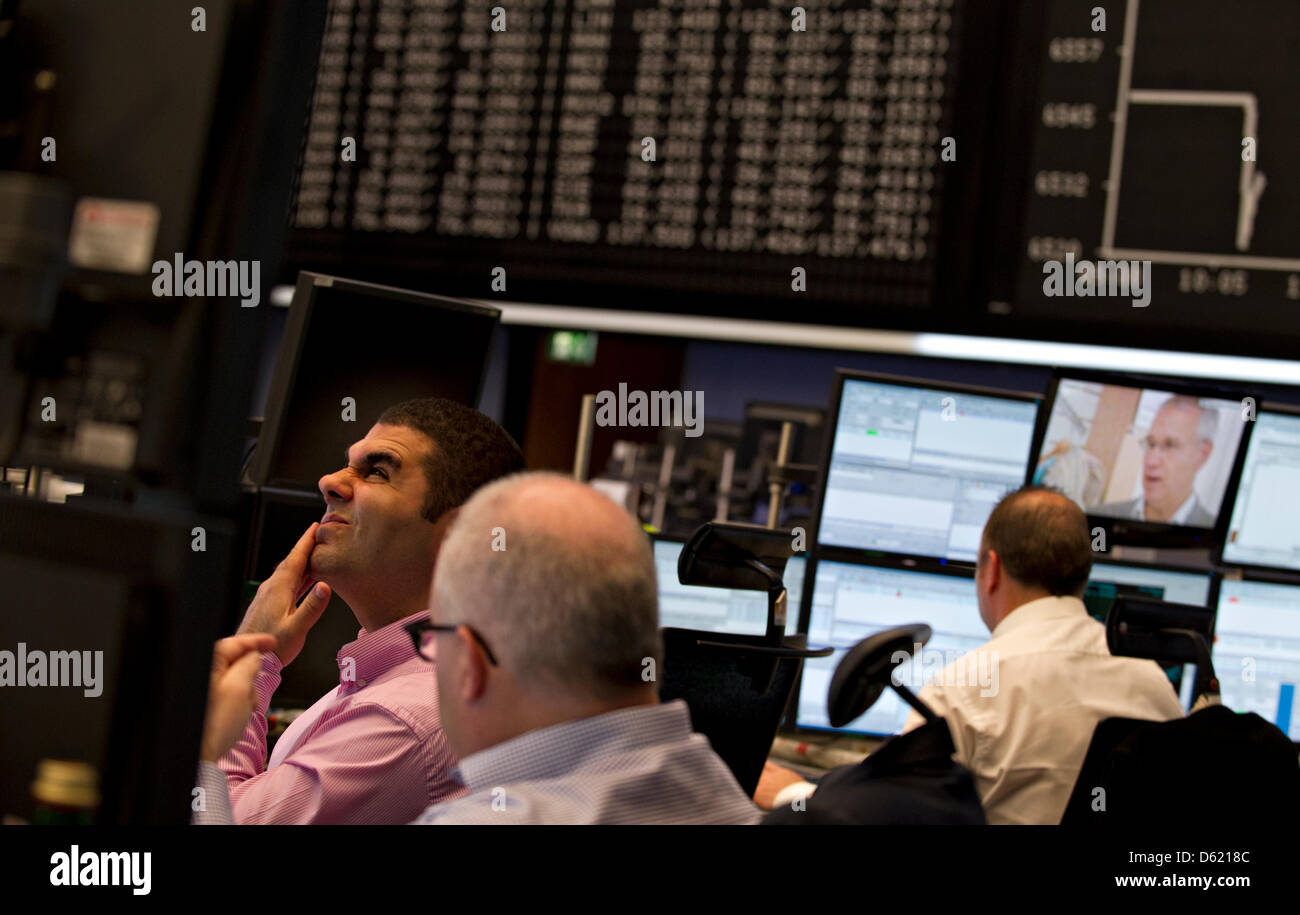 Brokers sit in front of the display panel showing the horizontal and ...