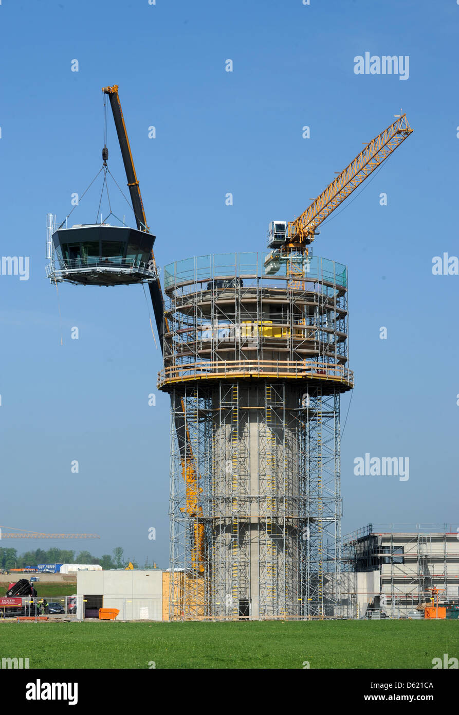 A turret is lifted by a crane onto the control tower at the new airport ...