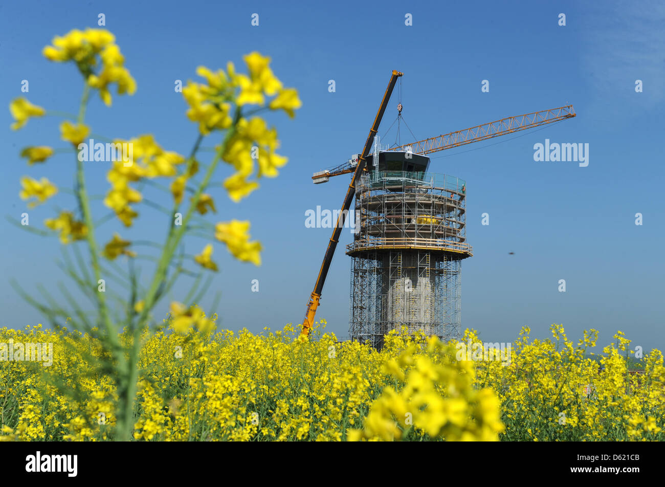 A turret is lifted by a crane onto the control tower at the new airport ...