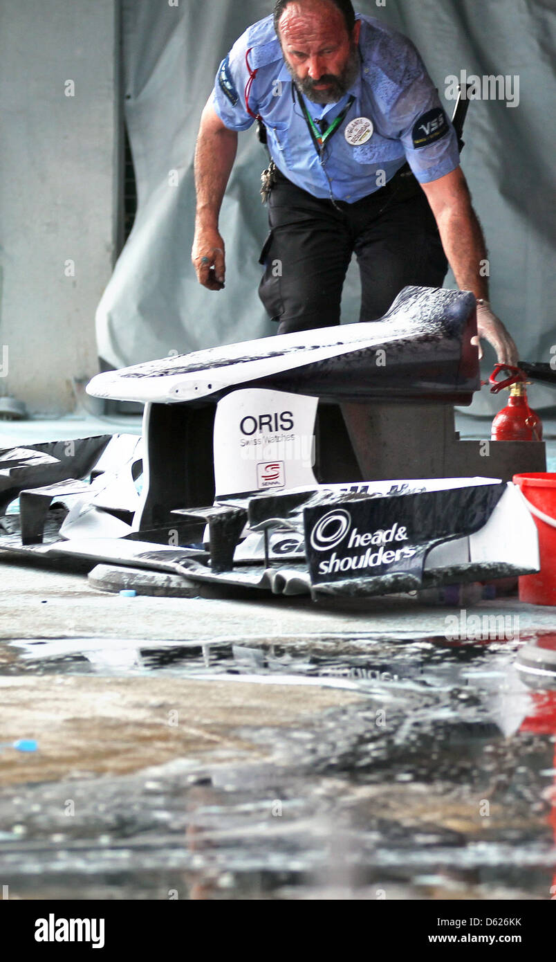 A security guard puts a fire extinguisher behind the front wing of a ...