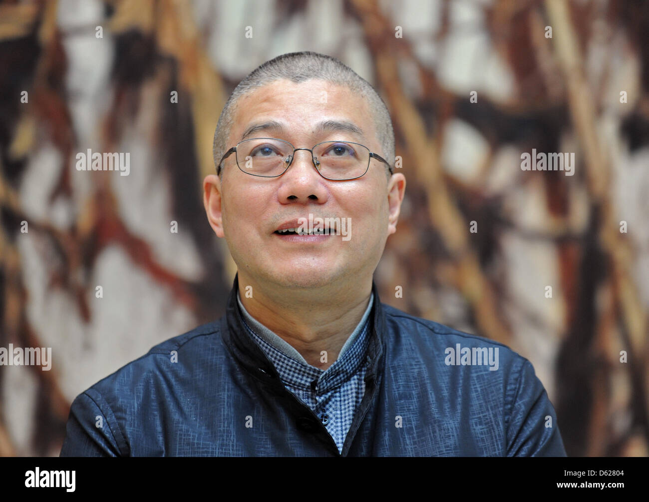 The Chinese artist Xu Jiang stands in front of his painting 'Will the ...