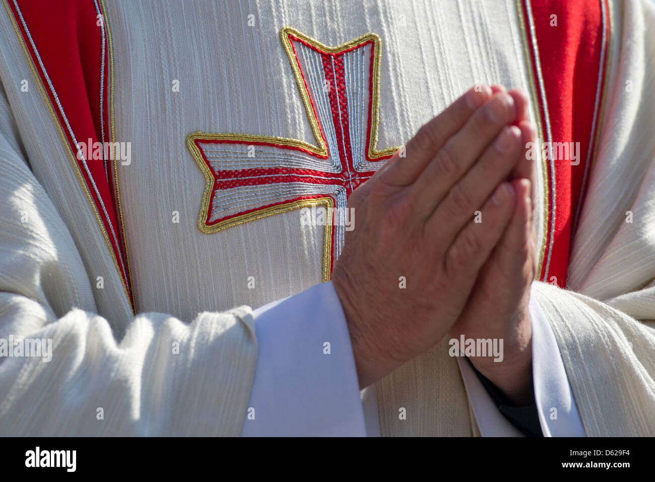 A bishop folds his hands in prayer during the opening service of the ...