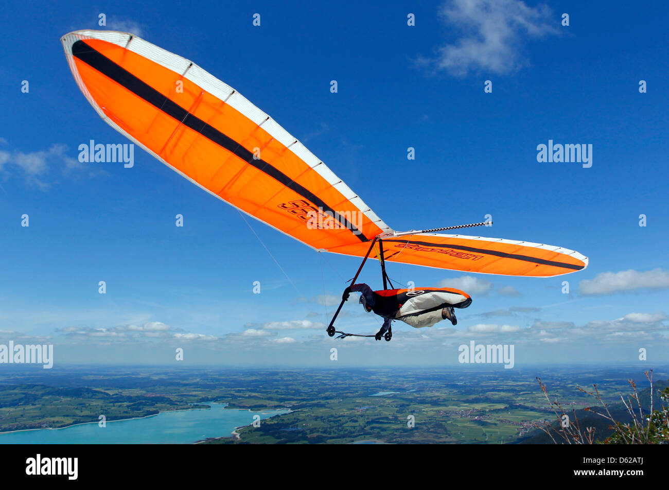 A hang glider flies over the Allgaeu landscape near Schwangau, Germany ...