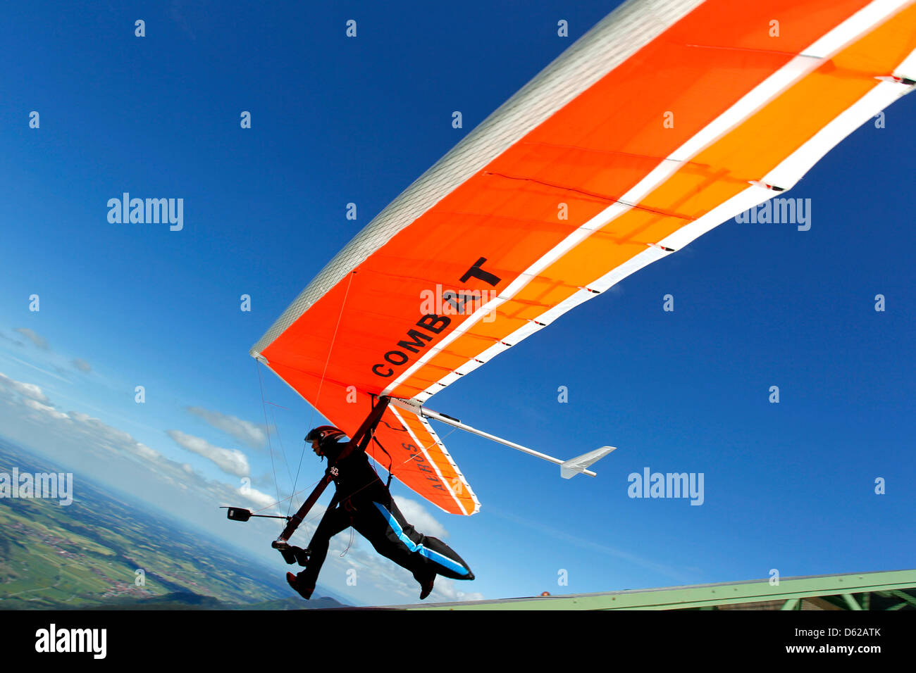 A hang glider flies over the Allgaeu landscape near Schwangau, Germany ...
