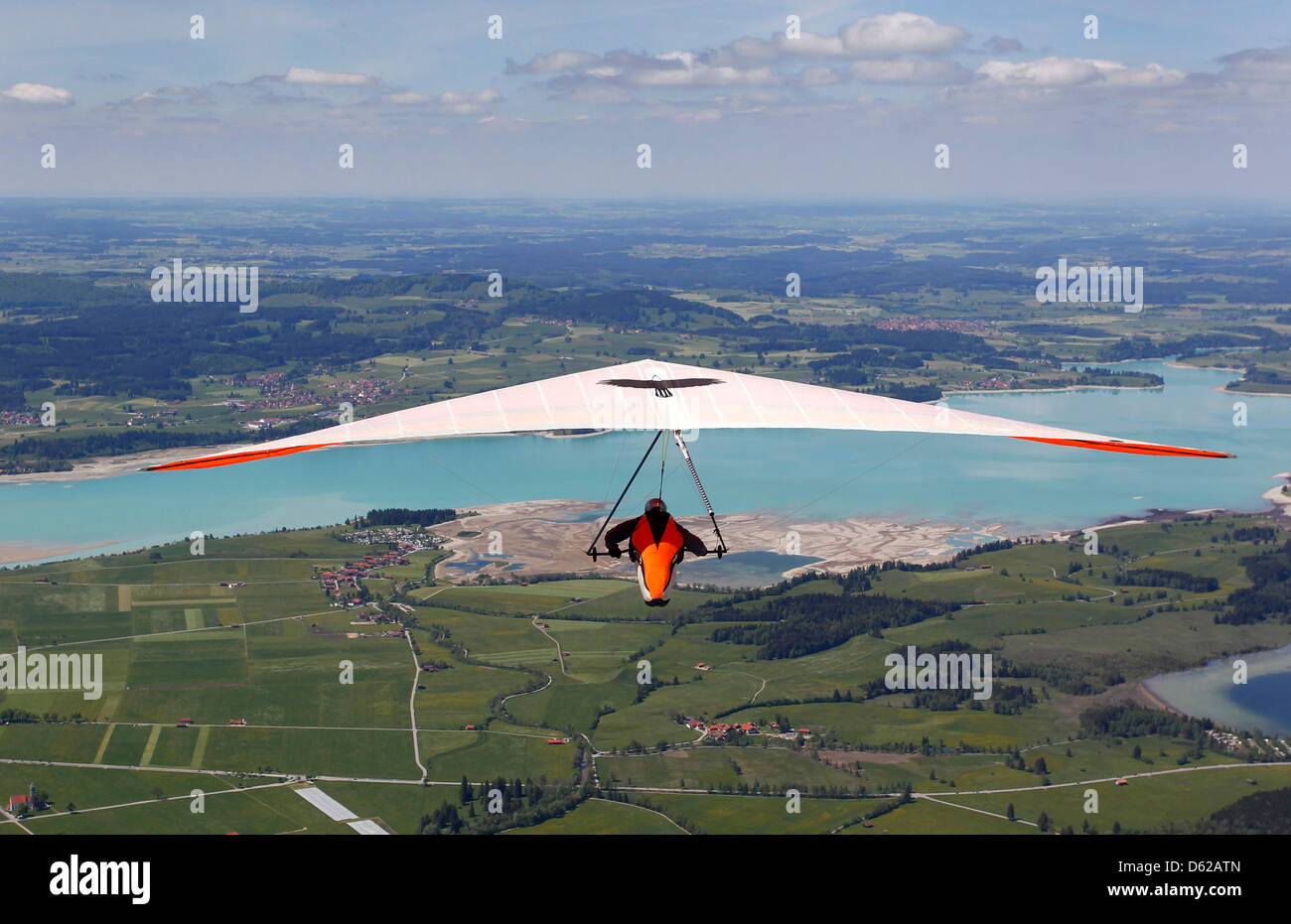 A hang glider flies over the Allgaeu landscape near Schwangau, Germany ...