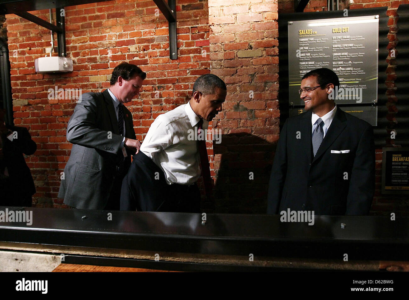 United States President Barack Obama gets assistance in putting on his ...