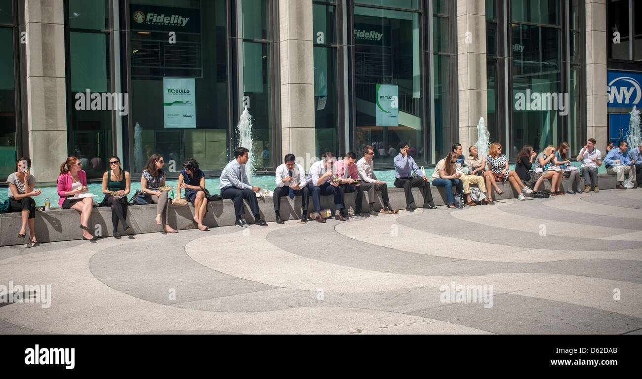 Office workers on their lunch hours sit outside the Time Life building ...