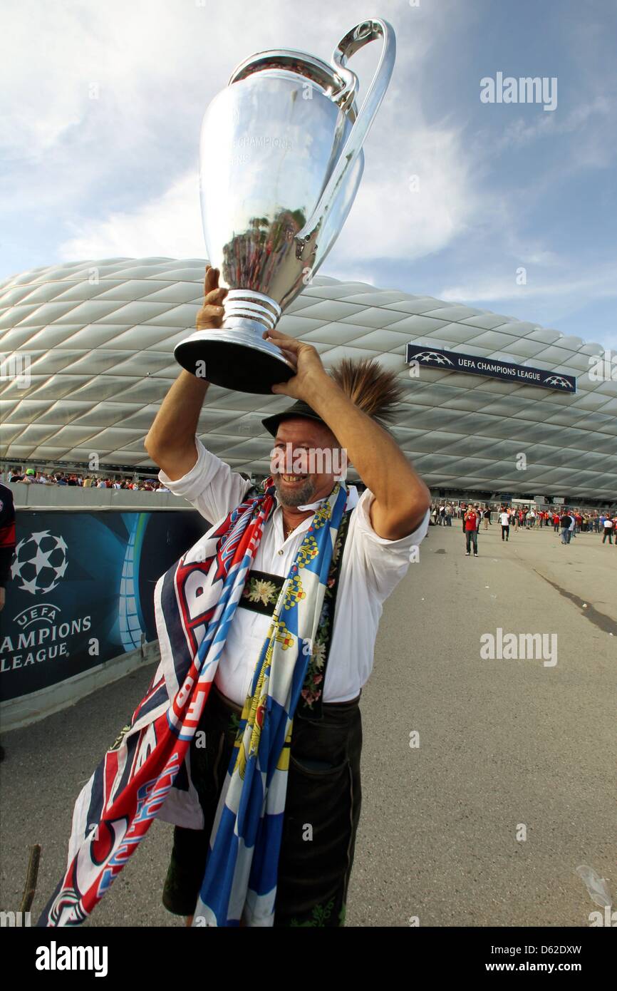 A fan in costume is photographed with a model of the cup prior to the ...