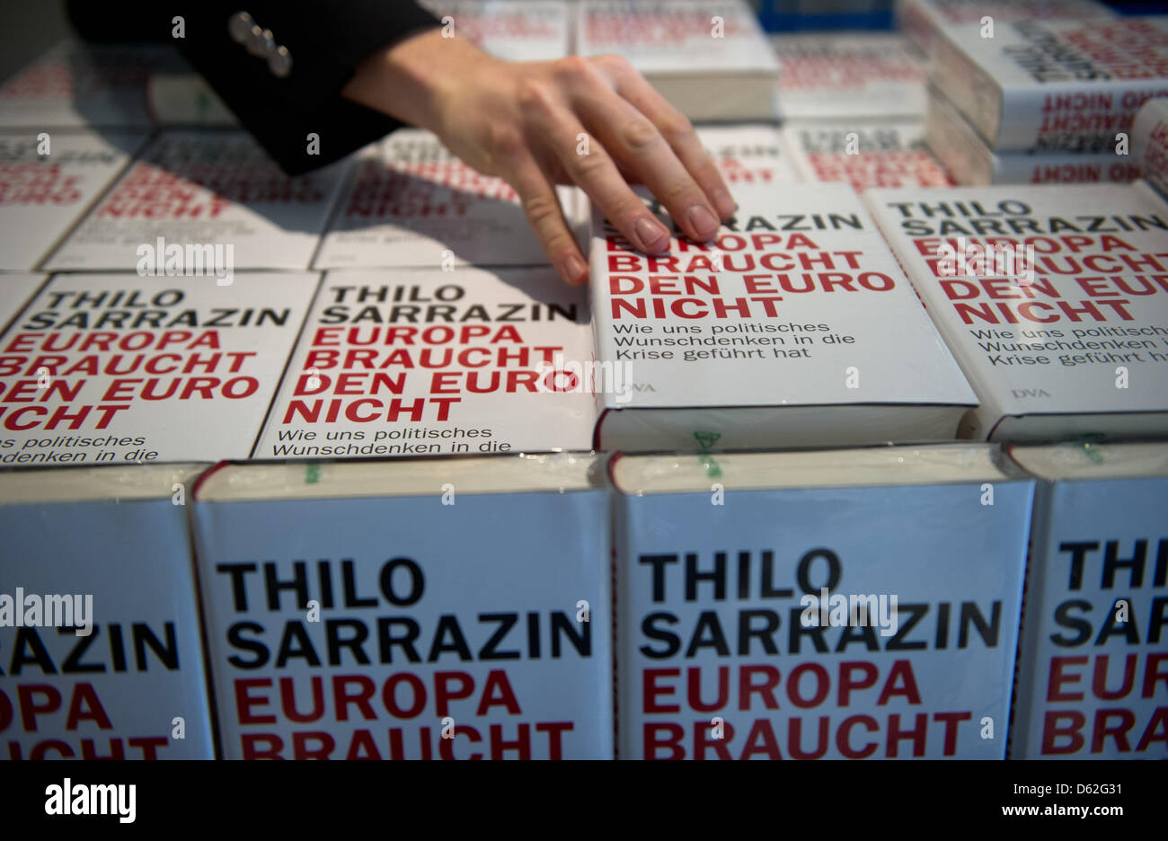 A hand grabs an edition of the new book of ex banker Thilo Sarrazin ...
