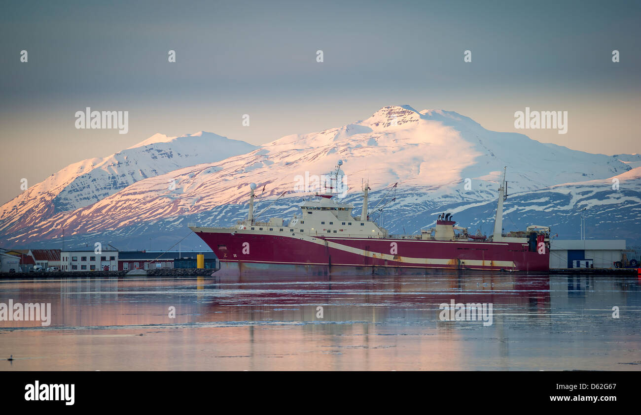 Fishing trawler docked at the harbor in Akureyri, Mt Kaldbakur in the ...