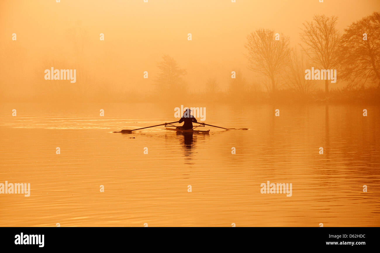 A rower at sunrise on the River Trent at Colwick Park in Nottingham ...