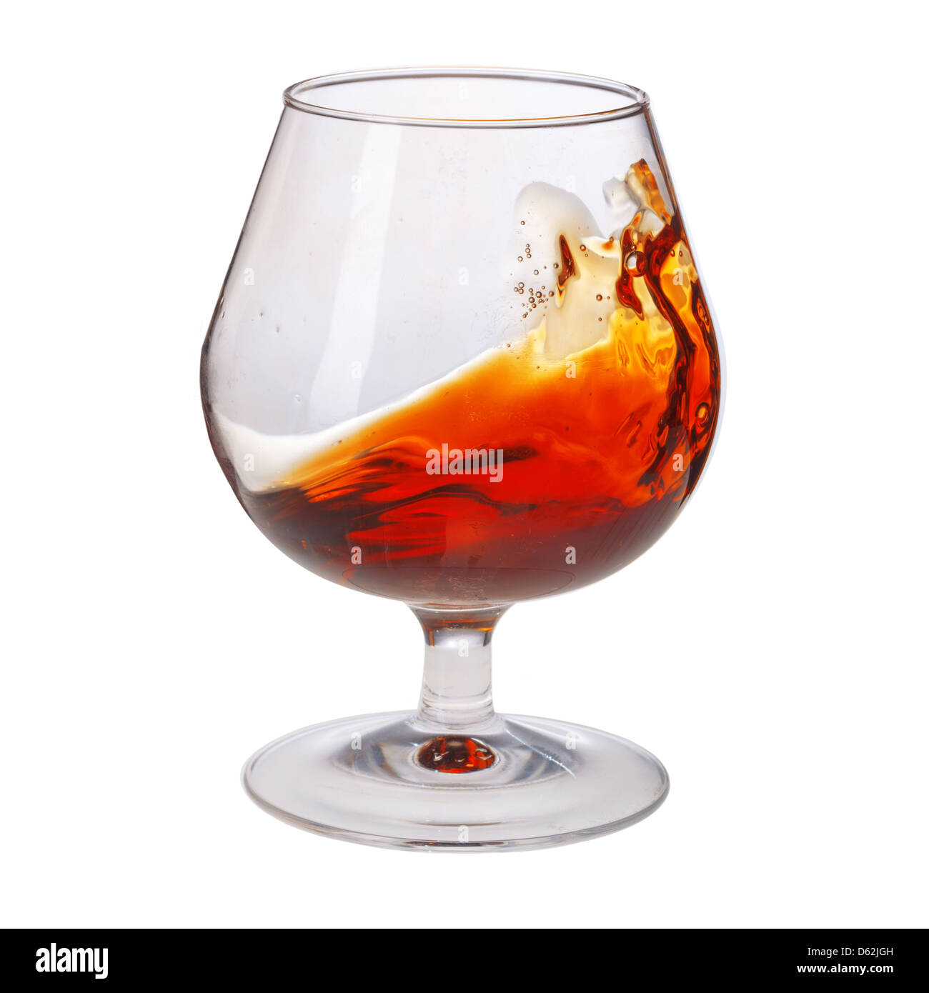 Splash of cognac in glass on white background Stock Photo - Alamy