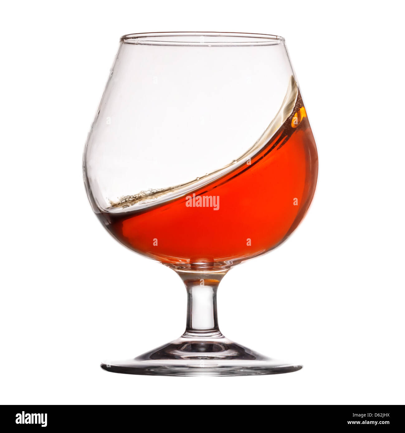 Splash of cognac in glass on white background Stock Photo - Alamy